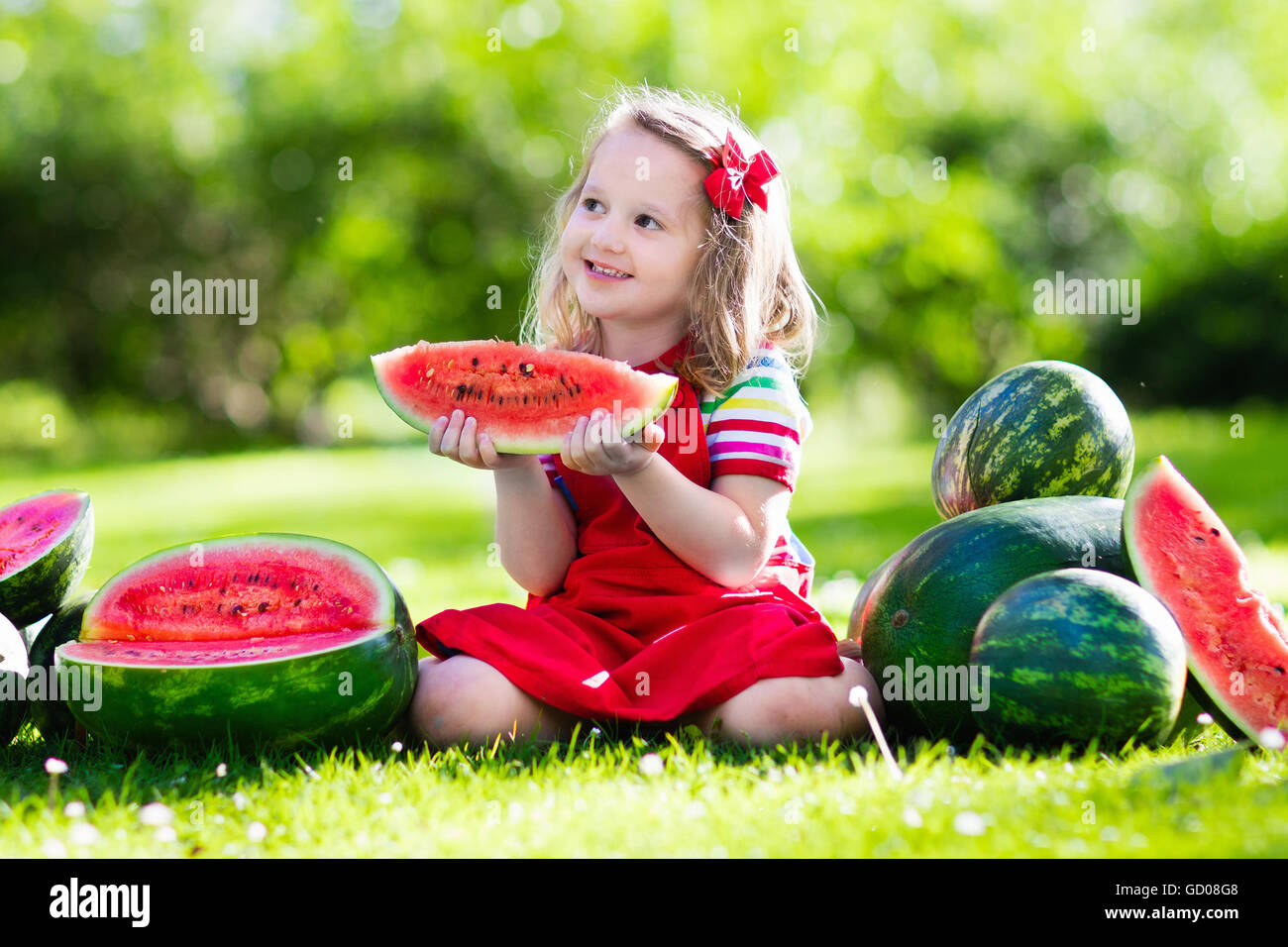 Child eating watermelon in the garden. Kids eat fruit outdoors. Healthy ...