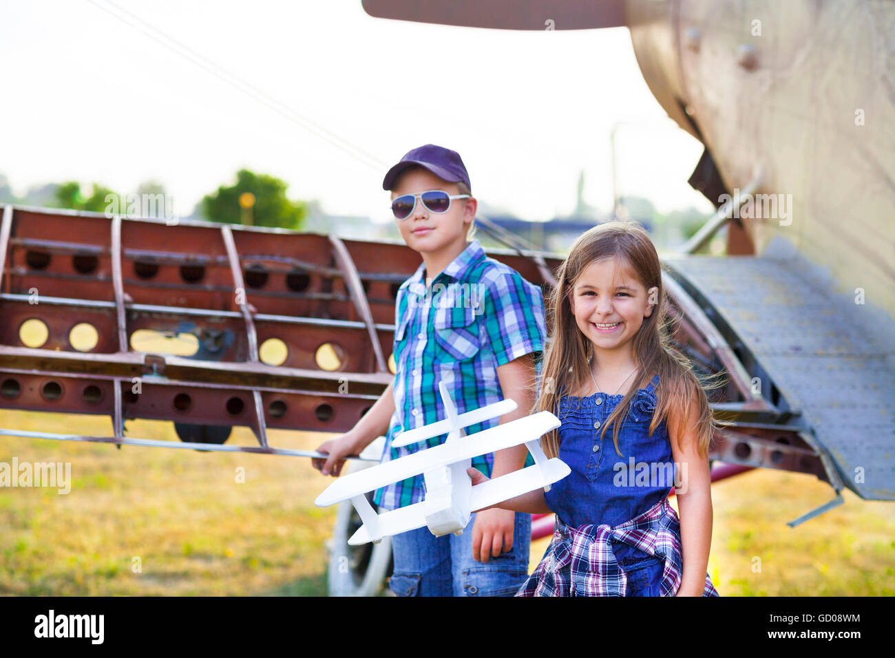 Little boy and little girl pilot with handmade plane at the airport ...