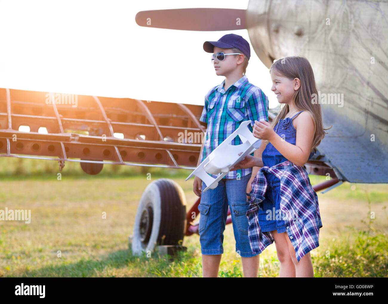 Little boy and little girl pilot with handmade plane at the airport ...