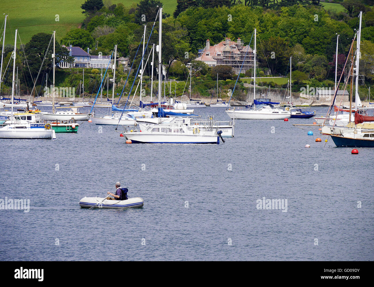 Man rows across harbor in inflatable dinghy Stock Photo - Alamy