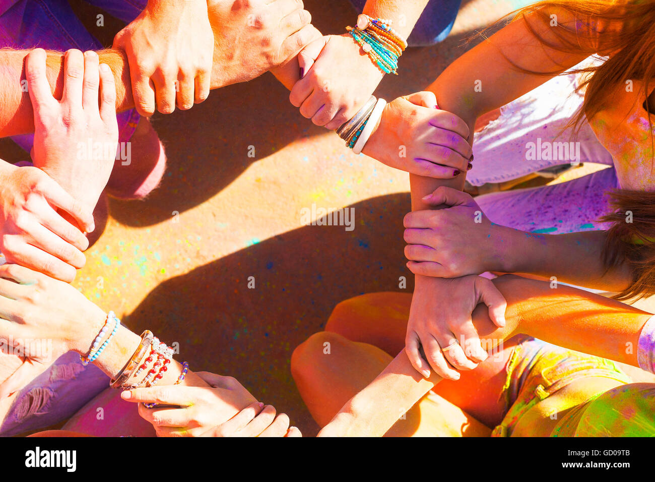 Friends putting their hands together in a sign of unity and teamwork ...