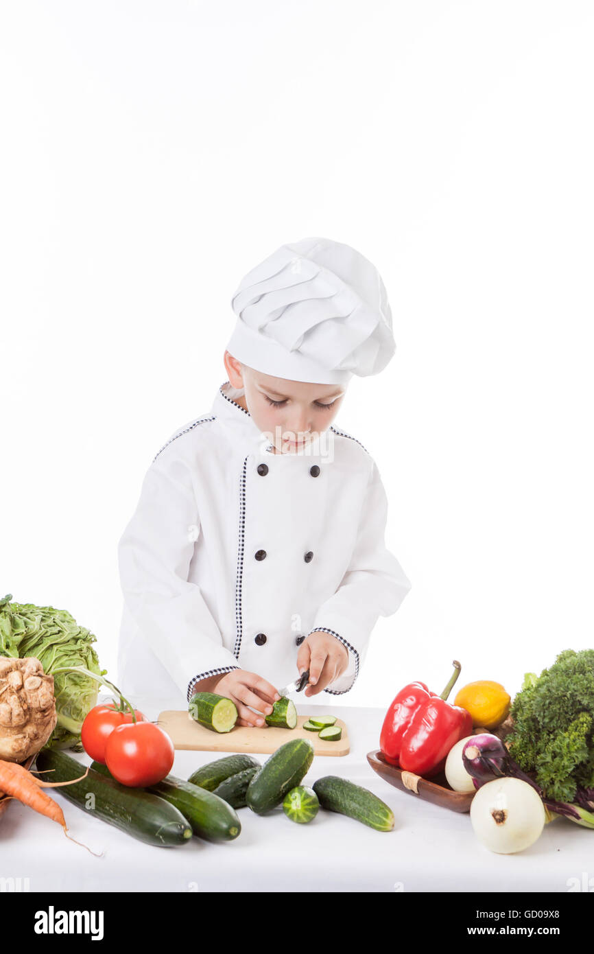 One little boy as chef cook making salad, cooking with vegetables ...