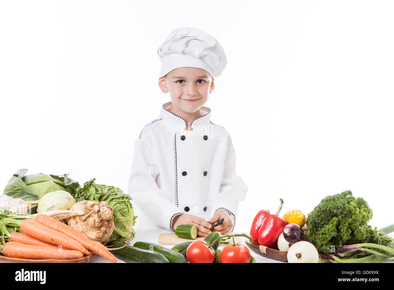 One little boy as chef cook making salad, cooking with vegetables ...