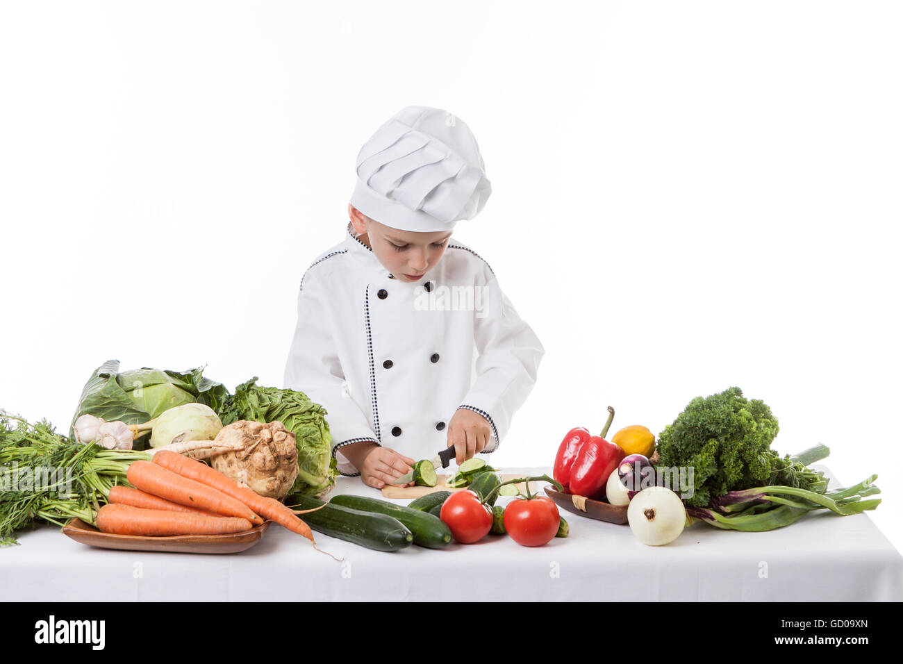 One little boy as chef cook making salad, cooking with vegetables ...