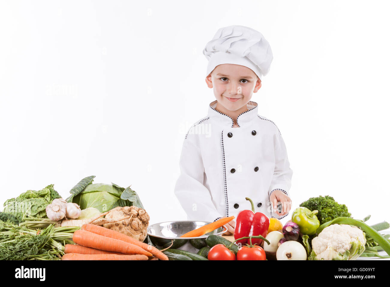 One little boy as chef cook making salad, cooking with vegetables ...