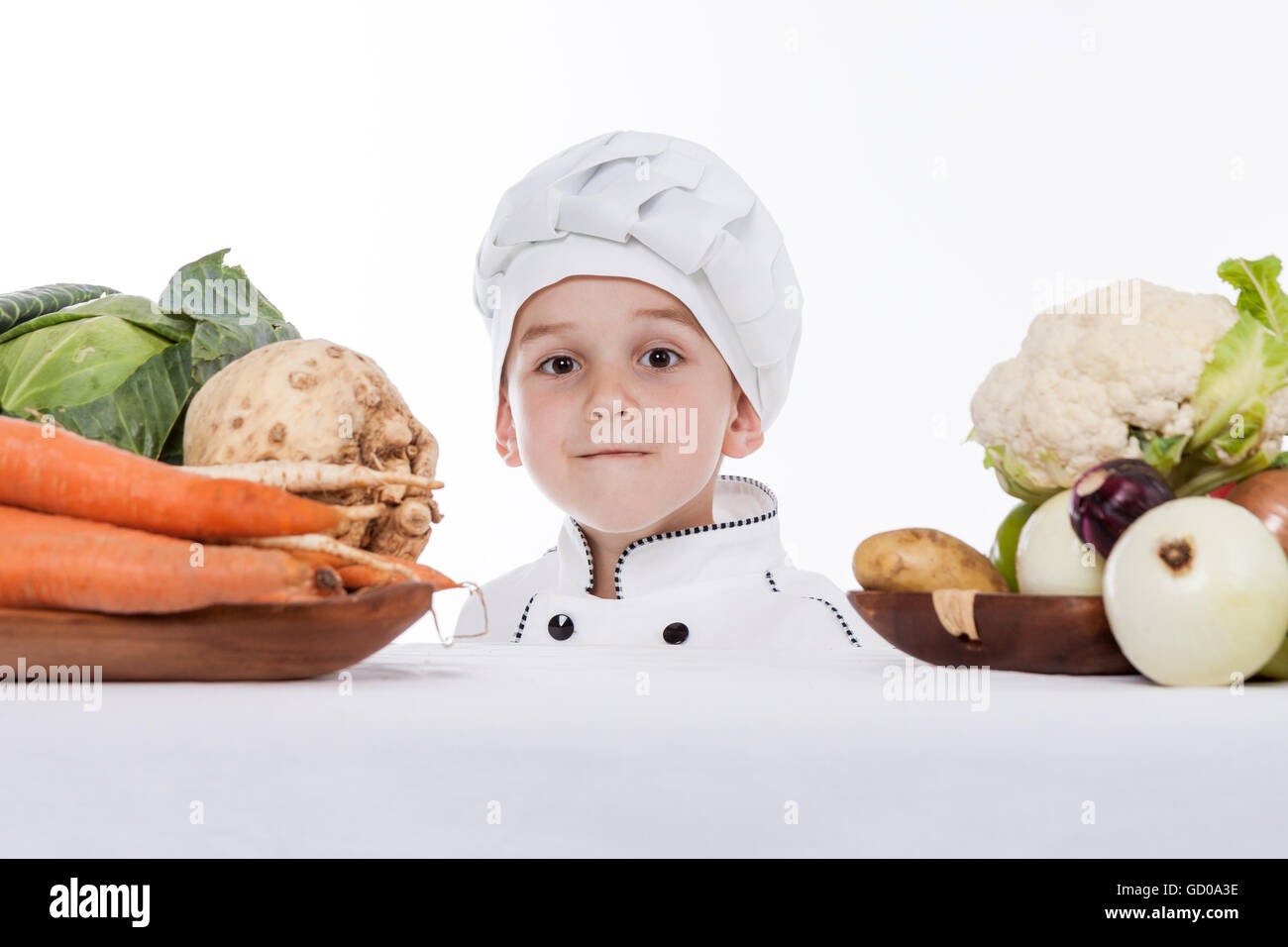 One little boy as chef cook making salad, cooking with vegetables ...