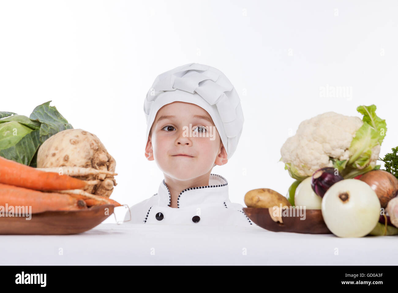 One little boy as chef cook making salad, cooking with vegetables ...