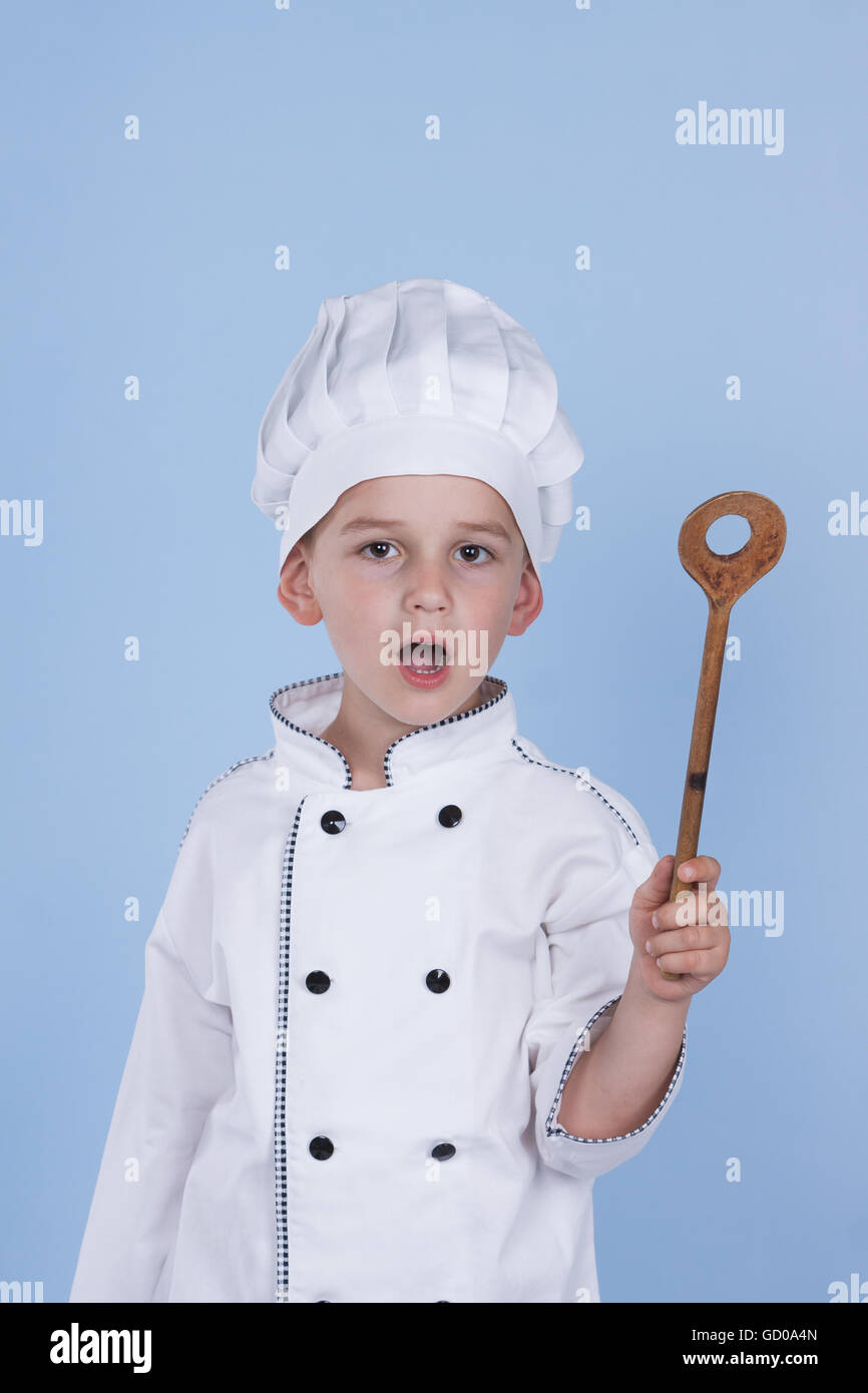 One little boy as chef cook making salad, cooking with vegetables ...