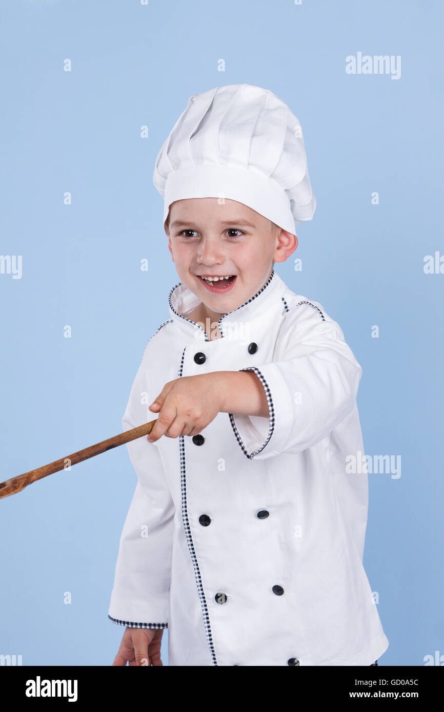 cheerful chef on a blue background with spoon Stock Photo - Alamy