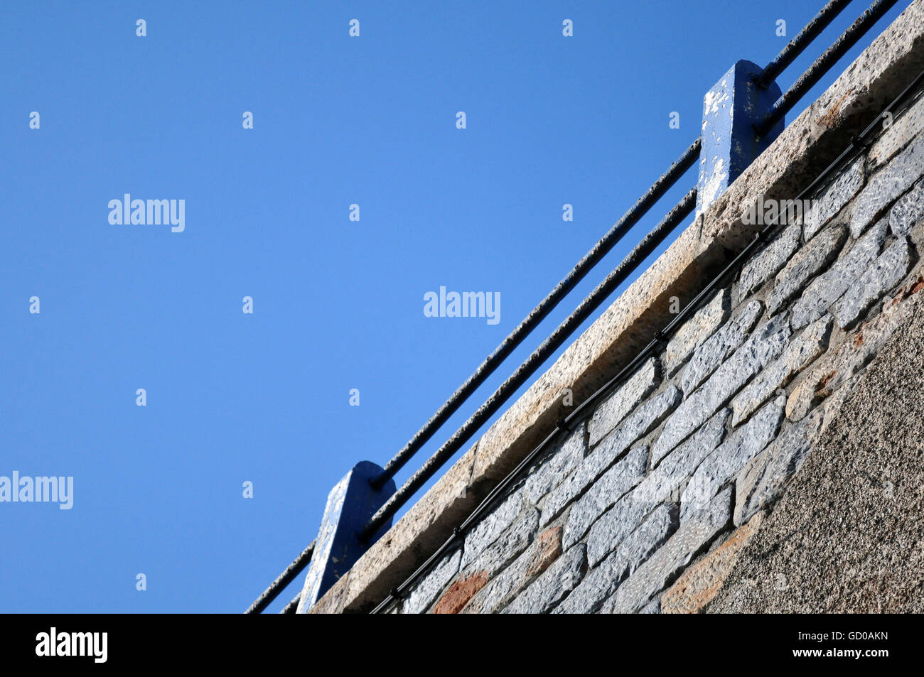 stone wall and railing diagonally on a blue cloudless sky Stock Photo ...