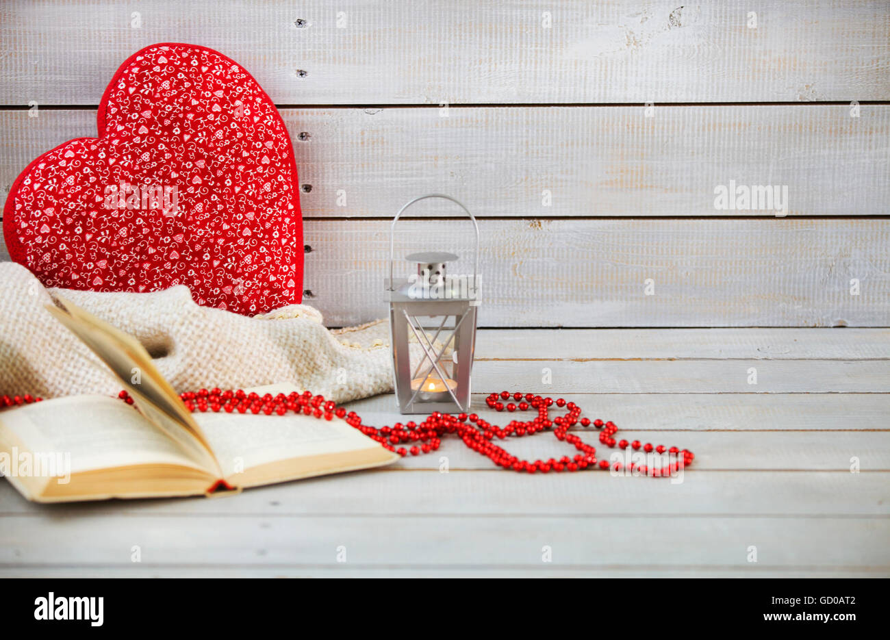 Christmas still life with lantern, pillow, book and red beads on wooden ...