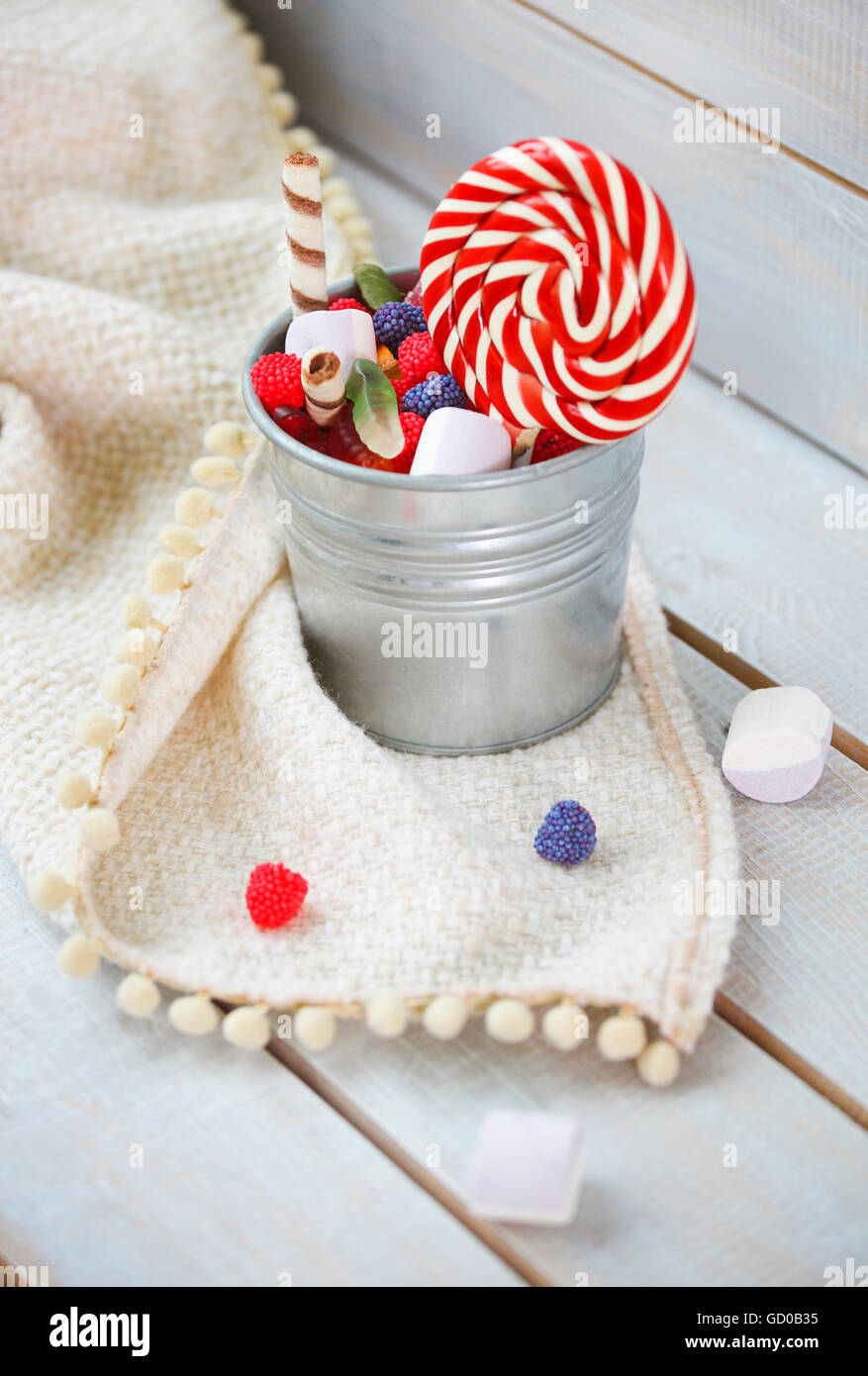 Colorful candies in a small bucket on light wooden background Stock ...
