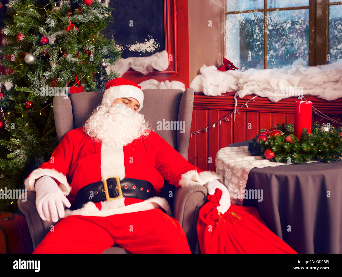 Photo of happy Santa Claus with big bag of presents sleeping at the ...