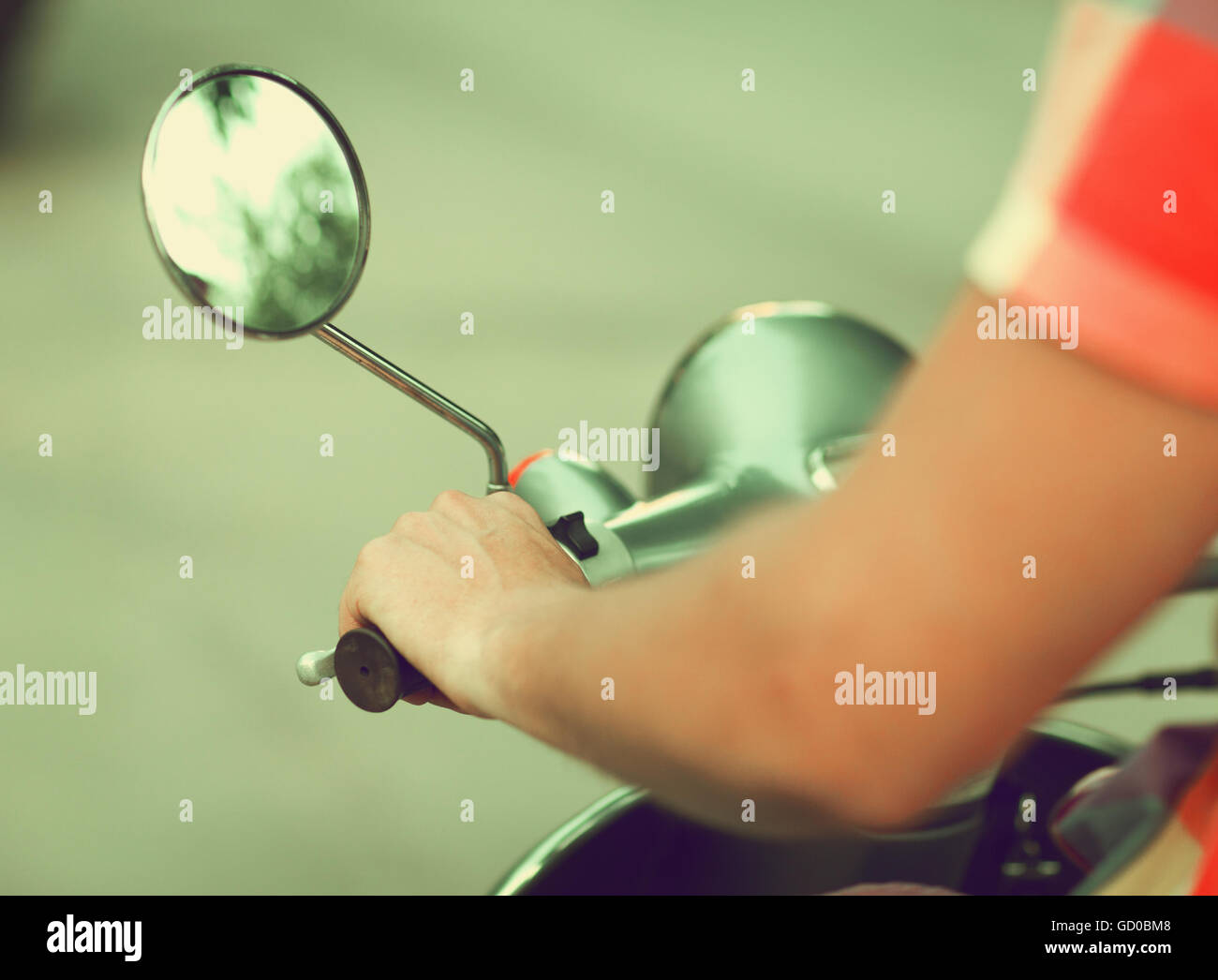 Young man riding old retro scooter in a city street. Close up Stock ...