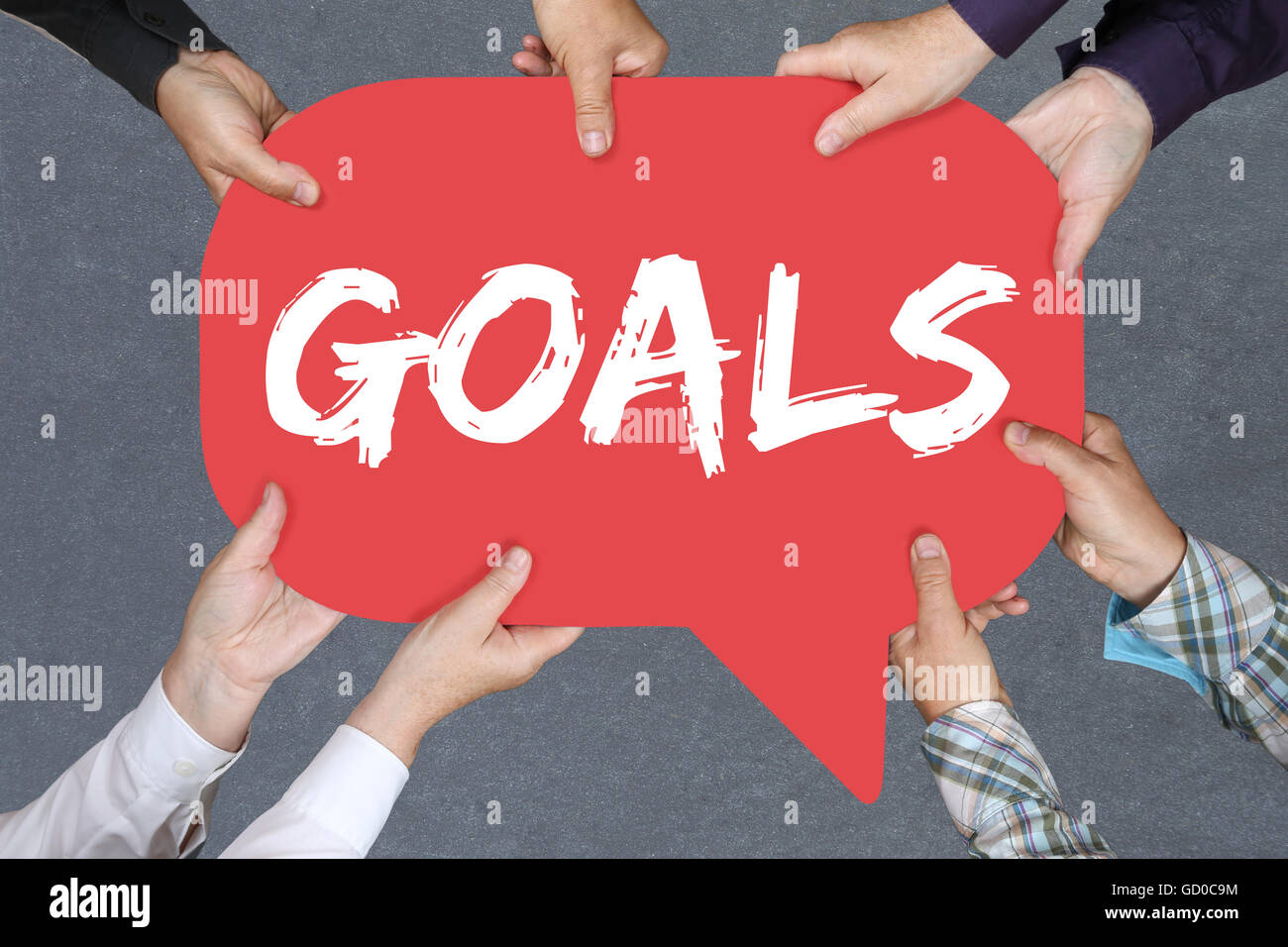 Group of people holding with hands the word goal goals to success ...
