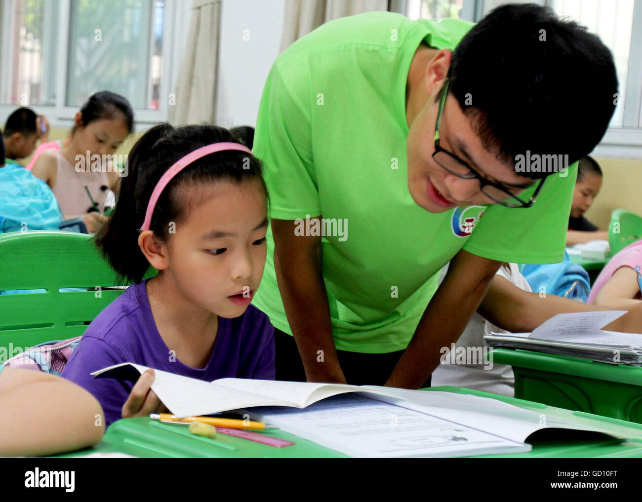 Shanghai, China. 11th July, 2016. A college student volunteer instructs ...