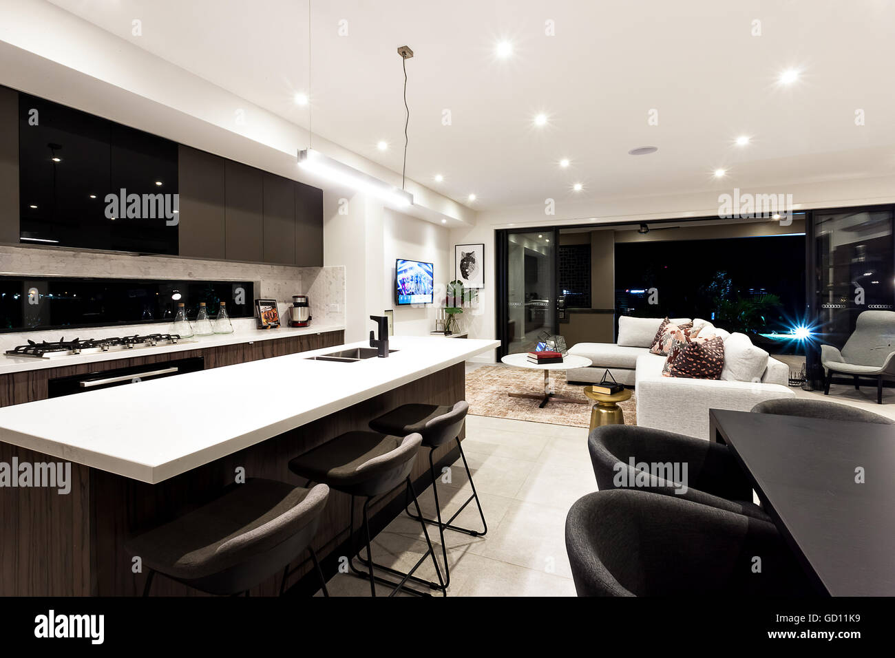 Hallway to a patio through the modern kitchen and dinner with tables ...