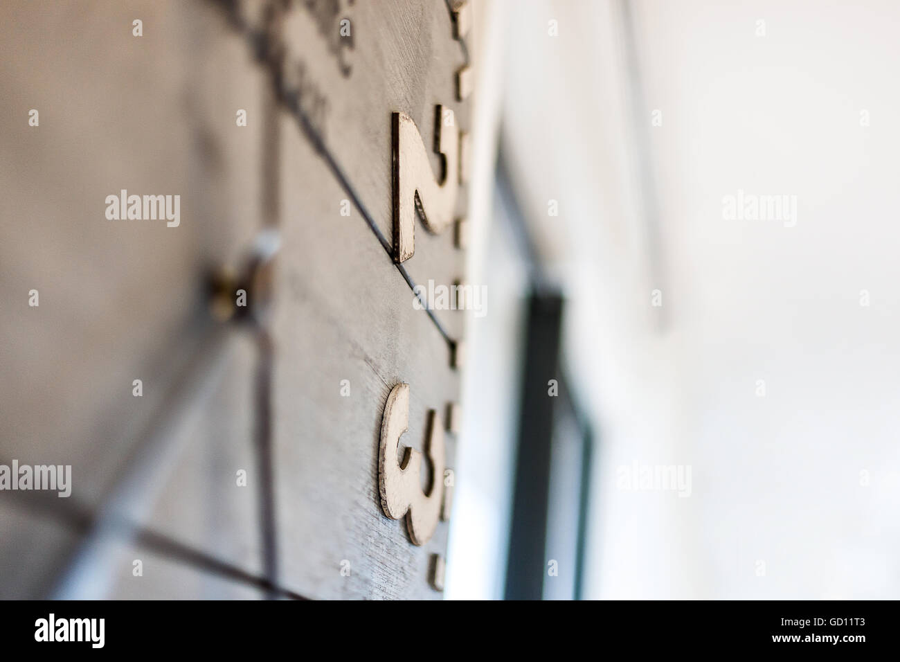 Closeup of a fancy wood clock focusing the 3d numbers on the middle and ...