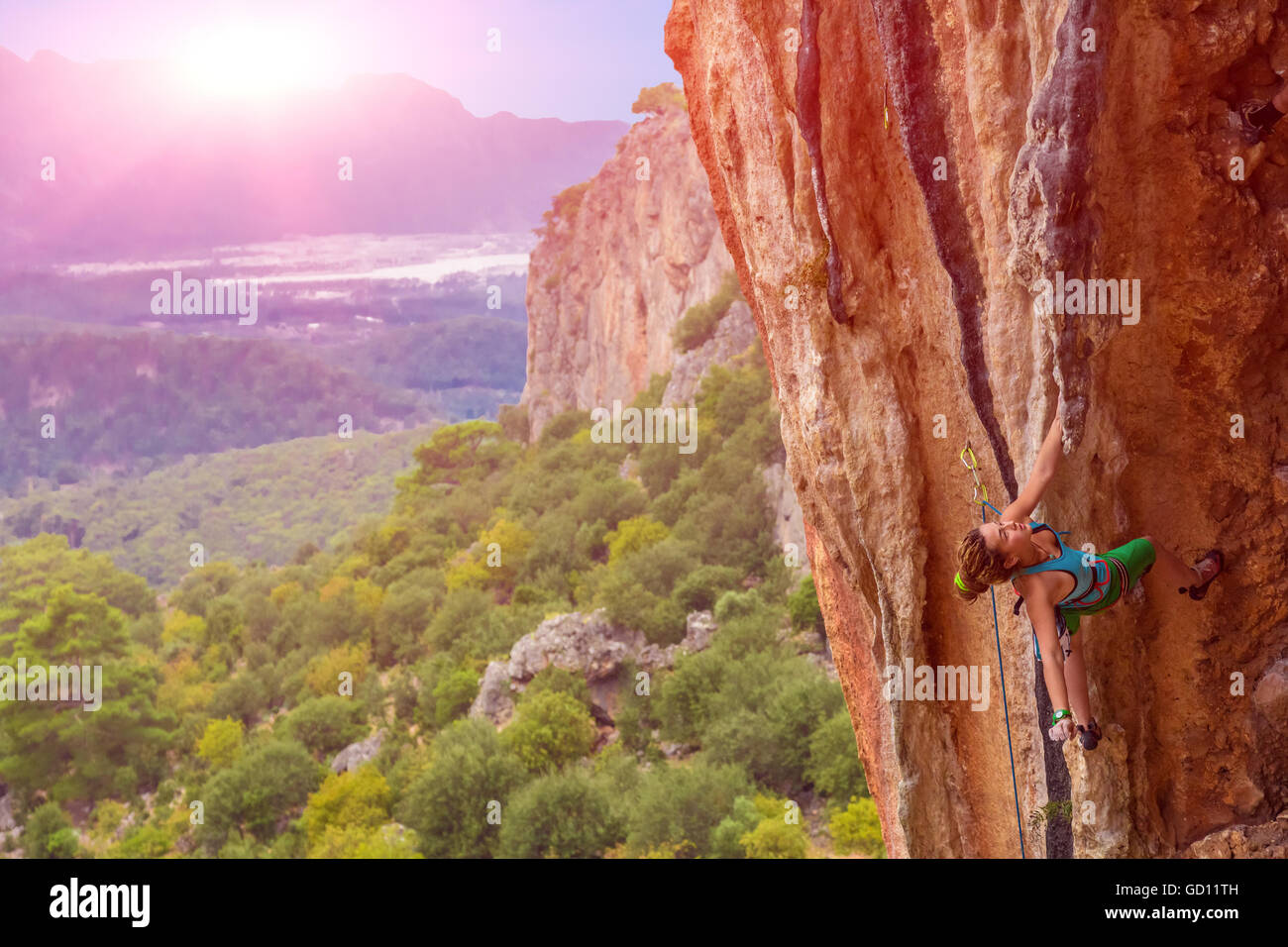 Young cute Climber Hanging on one hand on rocky Wall Stock Photo - Alamy