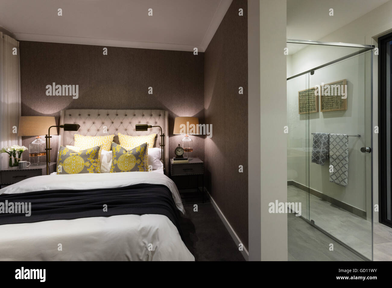Modern bedroom of a house or hotel attached to a bathroom shower area ...