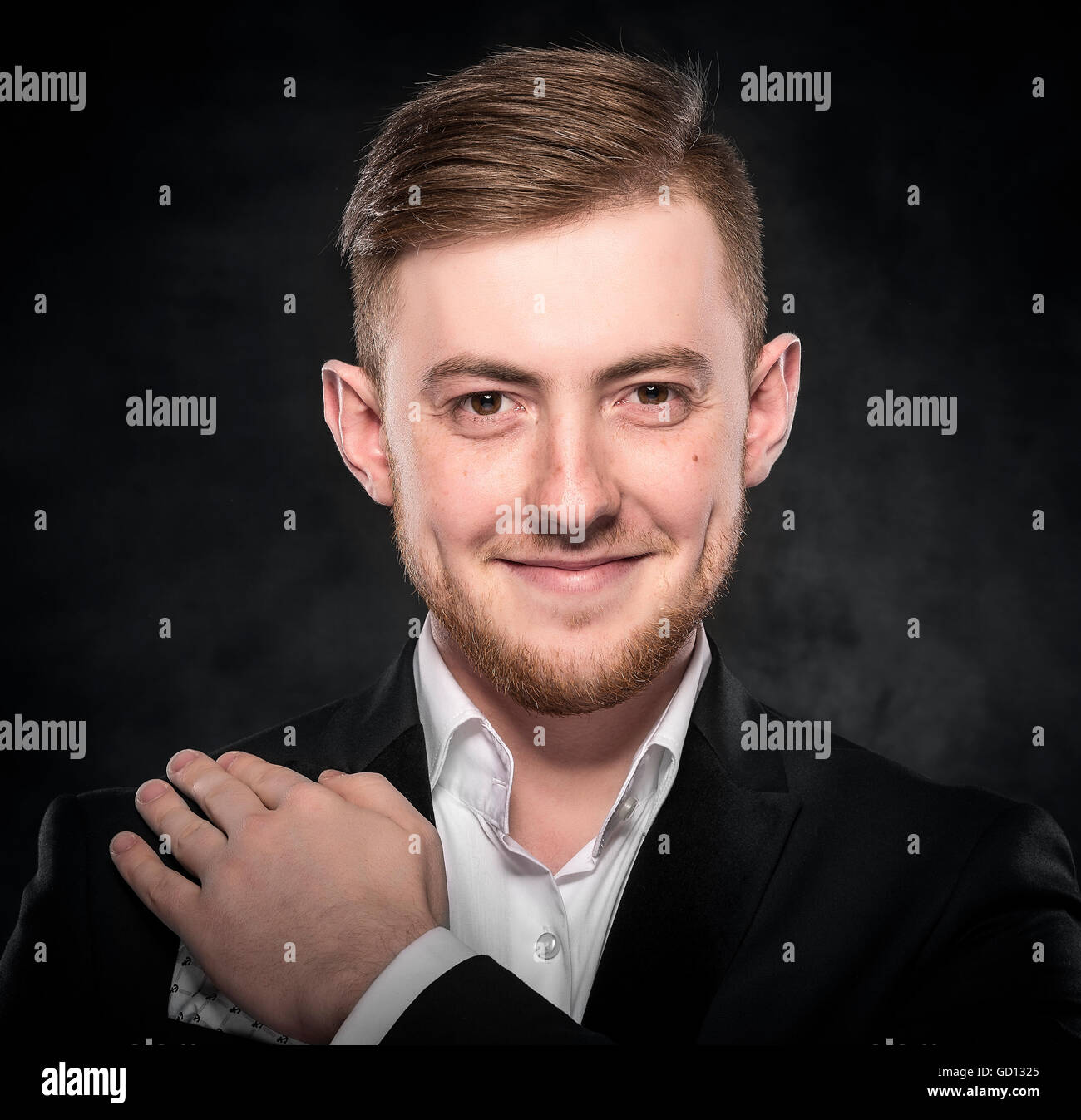 Young handsome man in suit smiling on dark background Stock Photo - Alamy