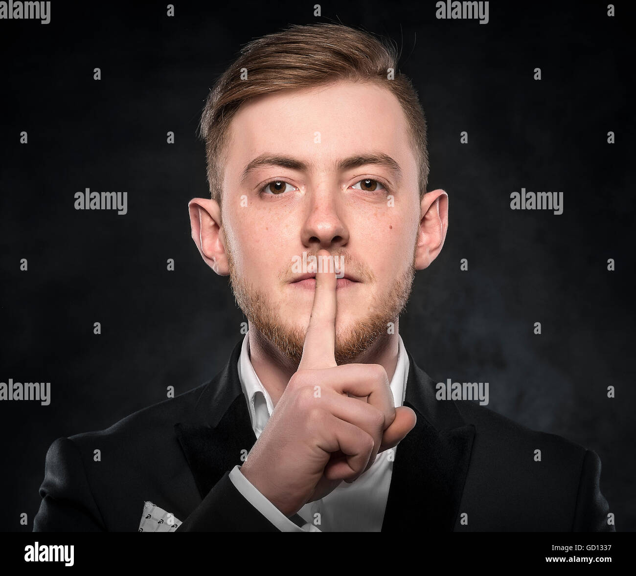 Man gesturing silent on a dark background Stock Photo - Alamy