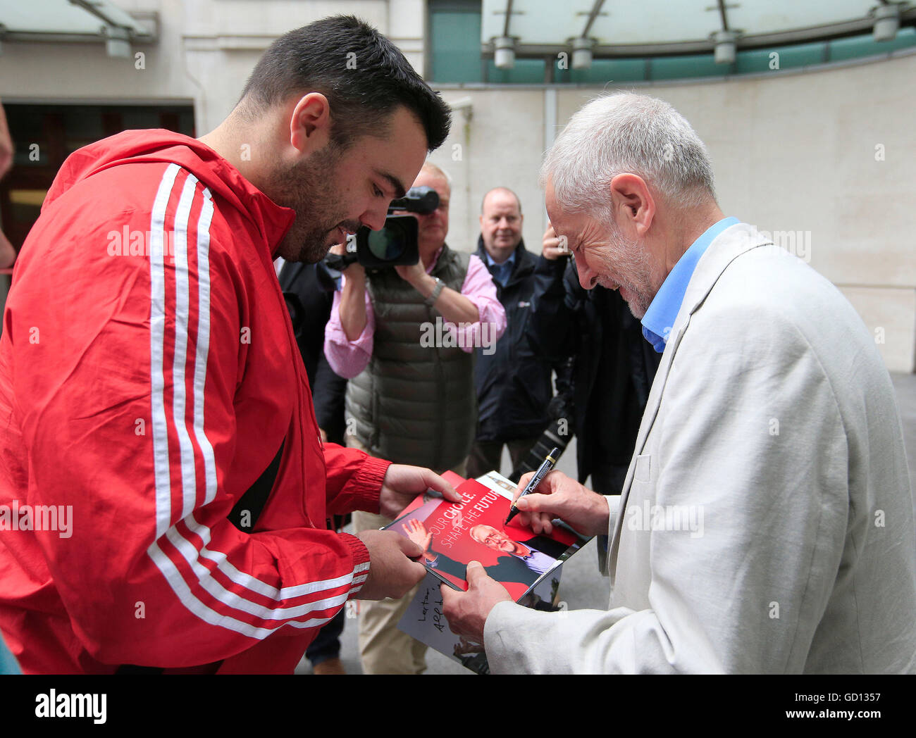 Labour Party leader Jeremy Corbyn, signs a photograph of himself, as he ...