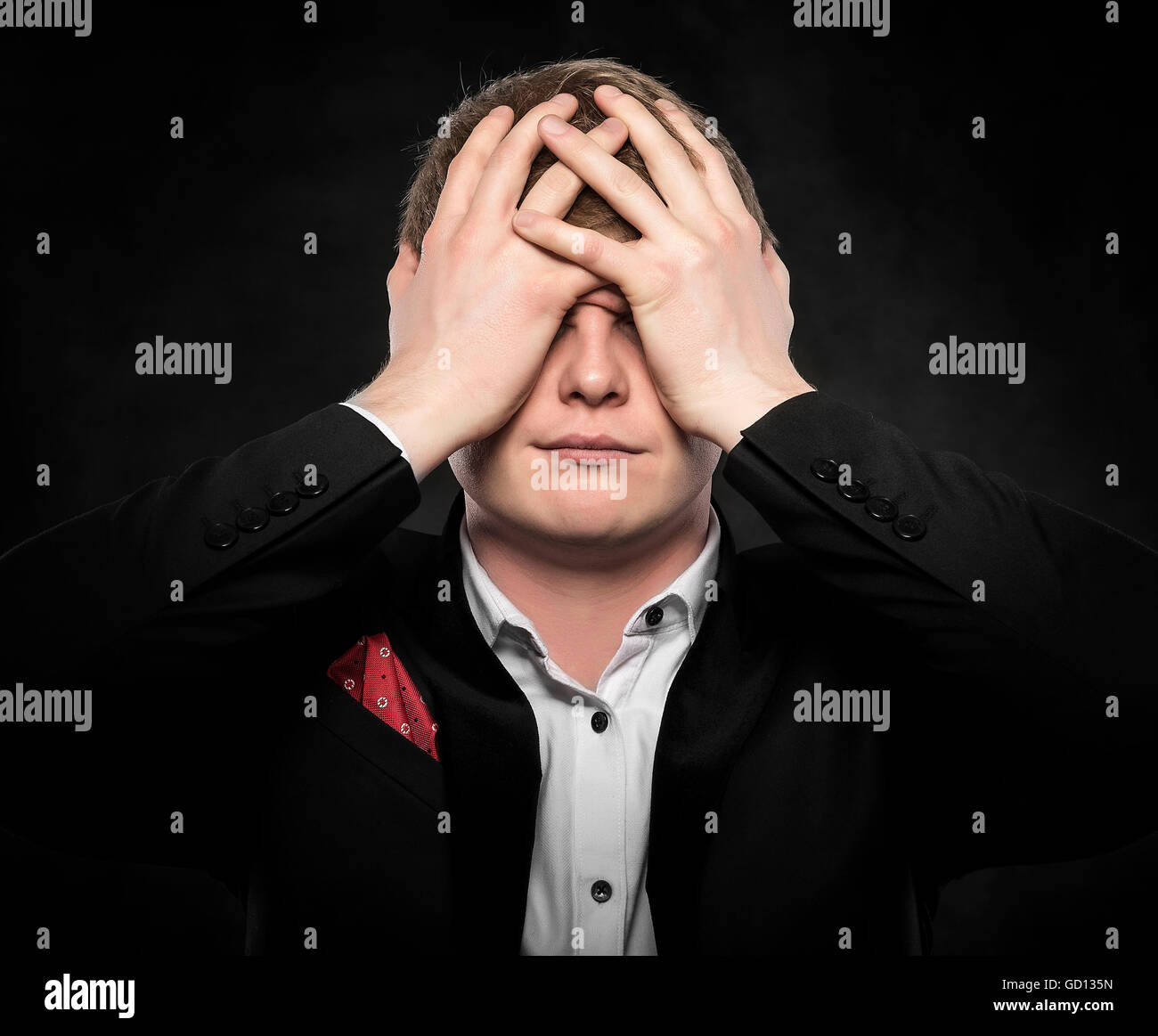 Young man holding his head feeling a headache or intensely thinking ...