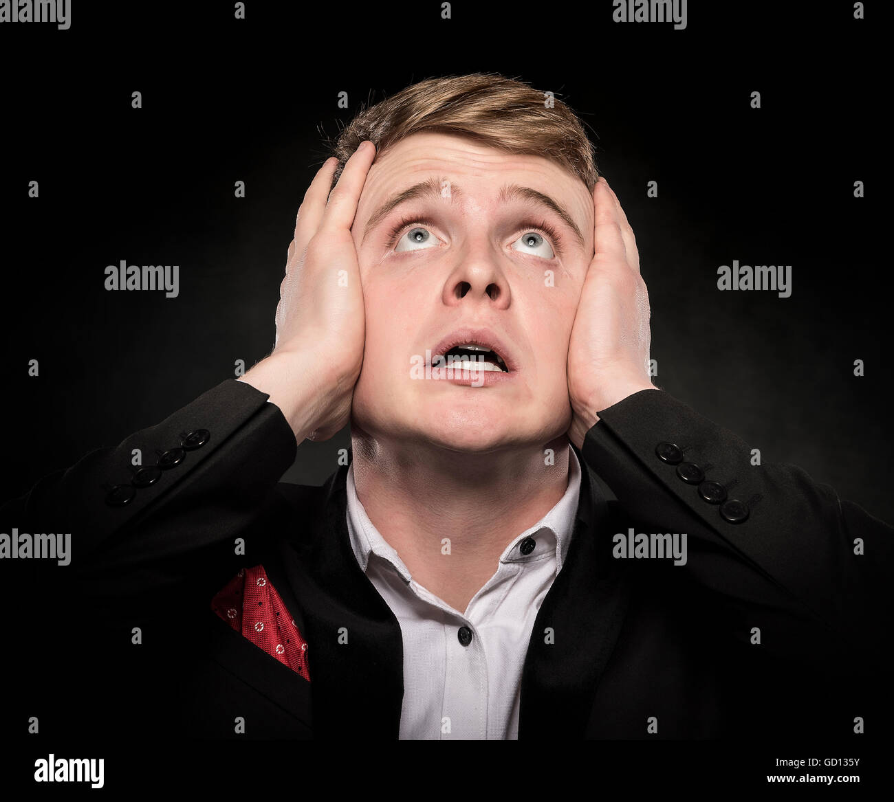 Young man holding his head feeling a headache or intensely thinking ...