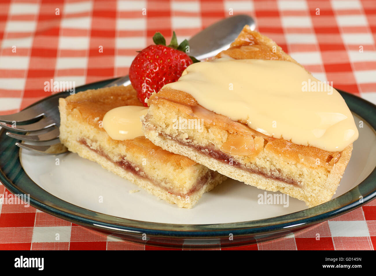 two slices of fresh bakewell pudding with a custard topping Stock Photo ...