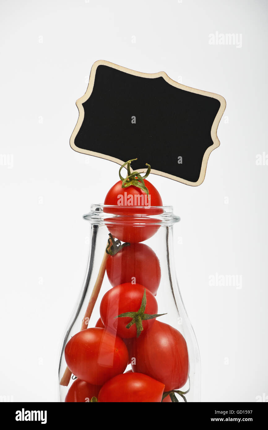 Big glass bottle full of cherry tomatoes and black chalkboard sign over ...