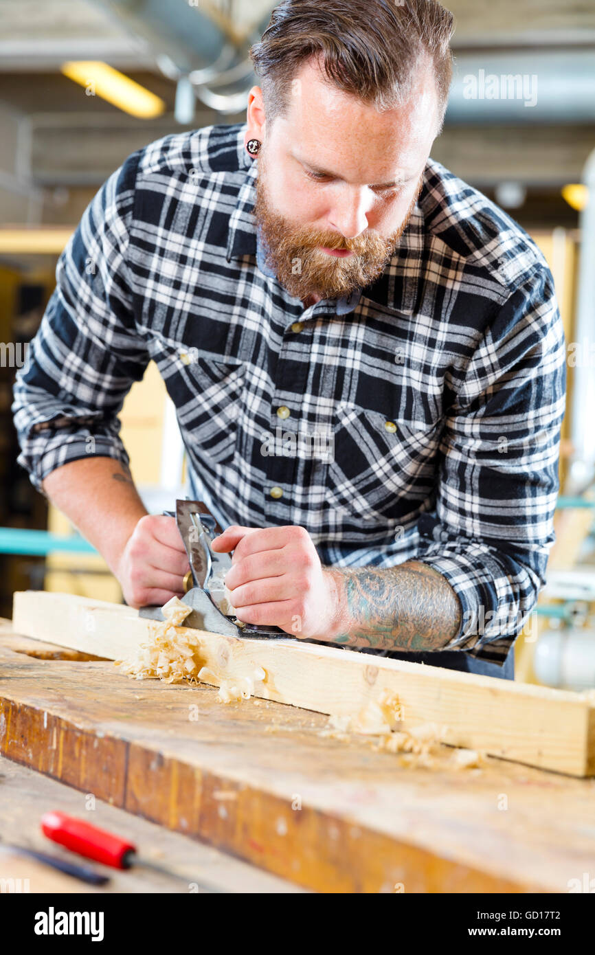 Carpenter work with planer on wood plank in workshop Stock Photo - Alamy