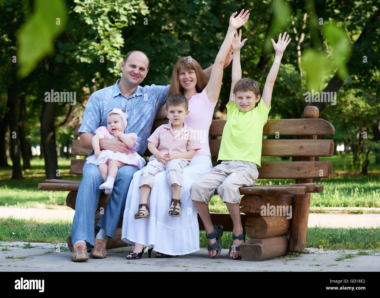 happy family portrait on outdoor, group of five people sit on wooden ...