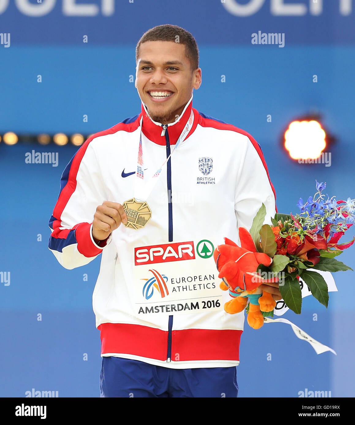 Great Britain's Elliot Giles holds up his bronze medal on the podium ...