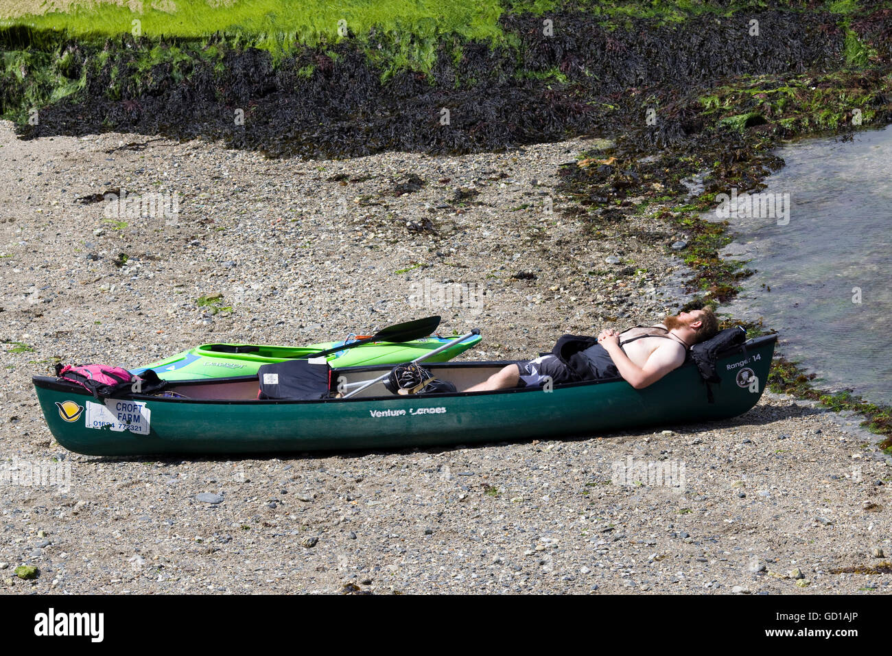 man laying in a venture canoe Stock Photo - Alamy