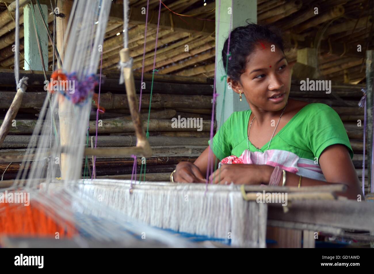 Golaghat, India. 10th July, 2016. A mishing tribal woman busy in ...