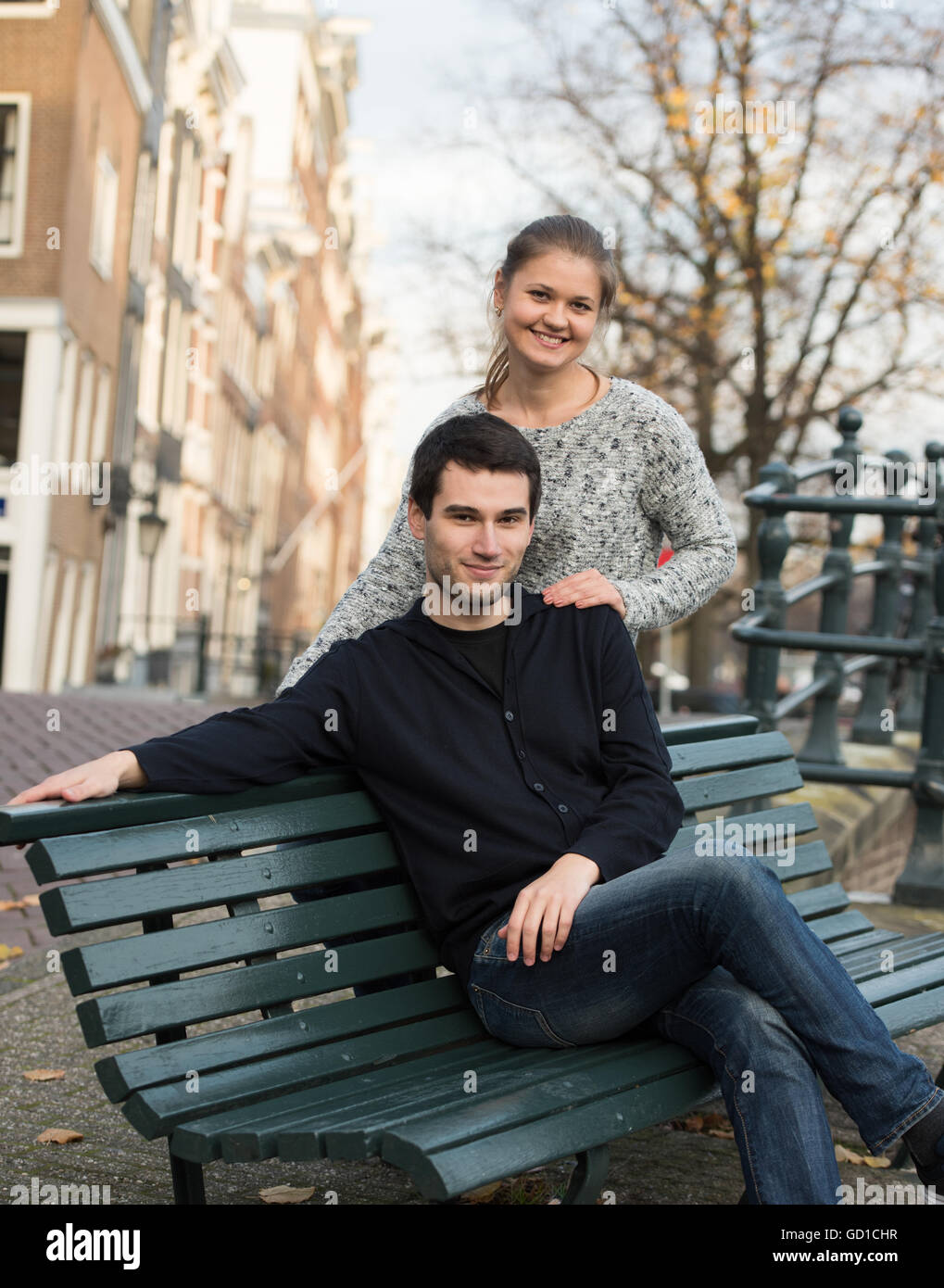 man in sitting on the bench in Amsterdam, Netherland, woman standing ...