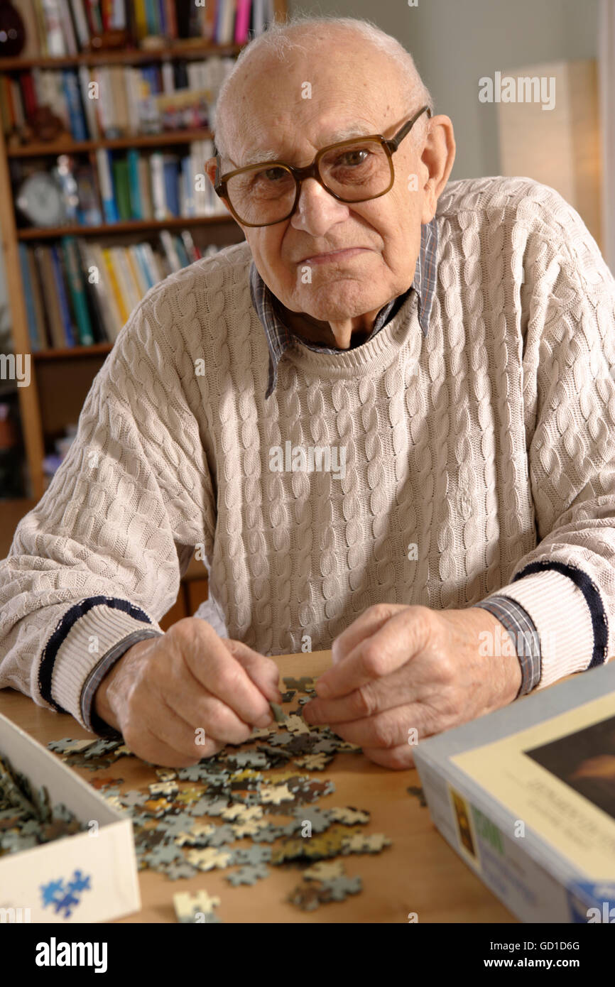 Elderly man, senior, 92, doing a puzzle Stock Photo - Alamy