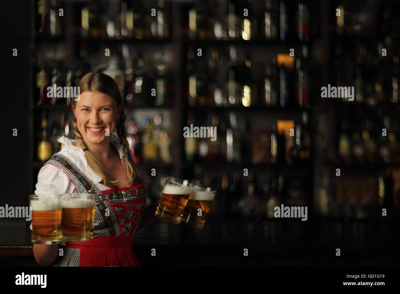 Pretty oktoberfest blonde woman holding beer mugs in bar Stock Photo ...