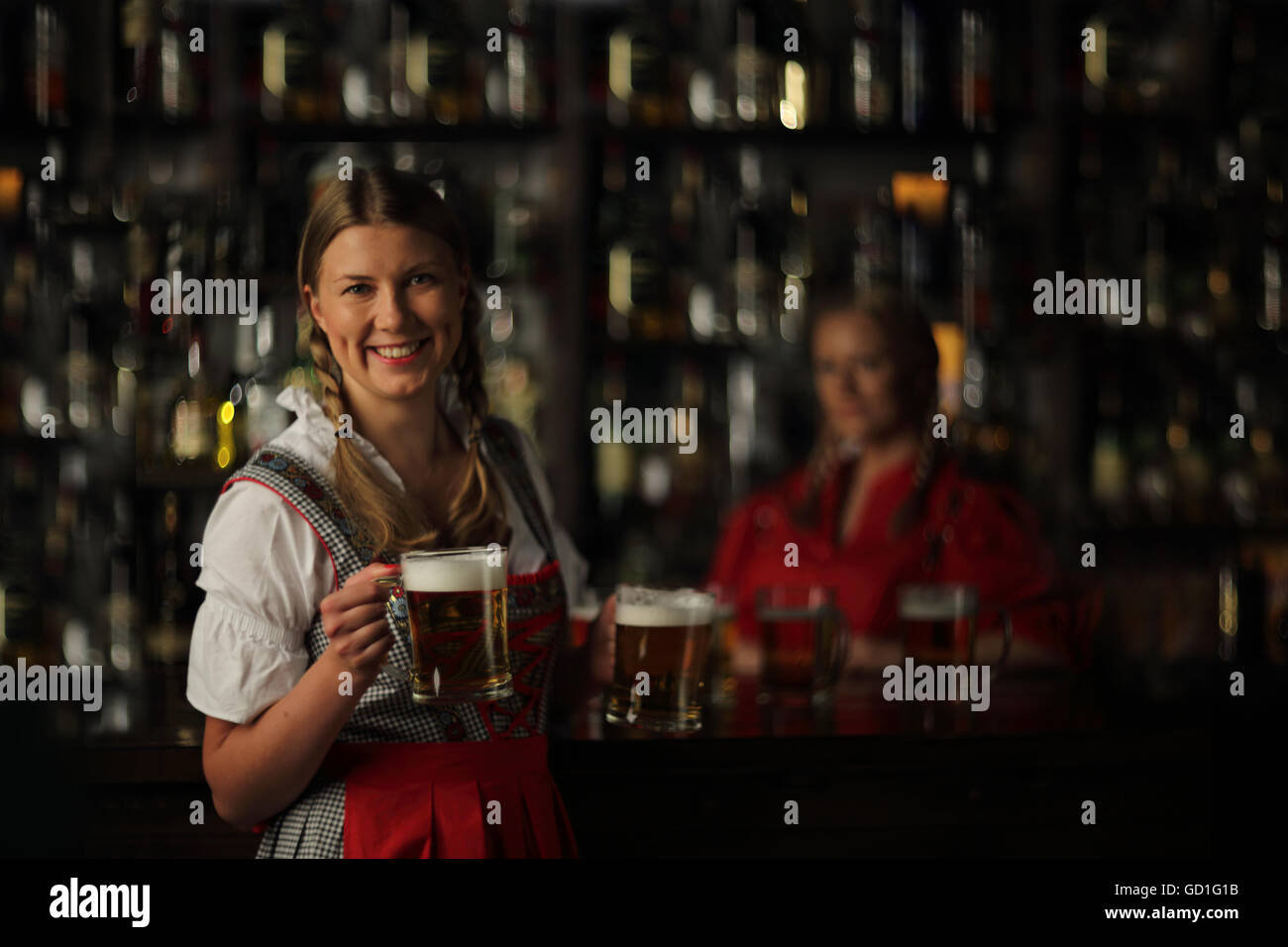 Pretty oktoberfest blonde woman holding beer mugs in bar Stock Photo ...