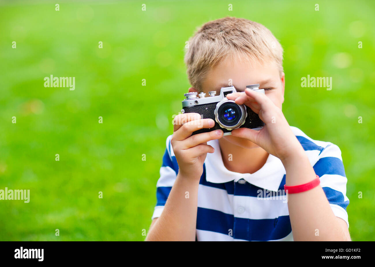 Happy smiling little boy with retro vintage camera in summer park Stock ...