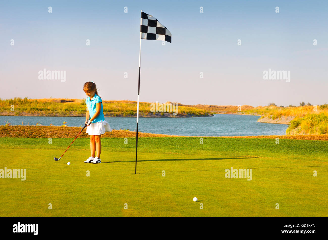 Cute little girl playing golf on a field outdoor. Summertime Stock ...