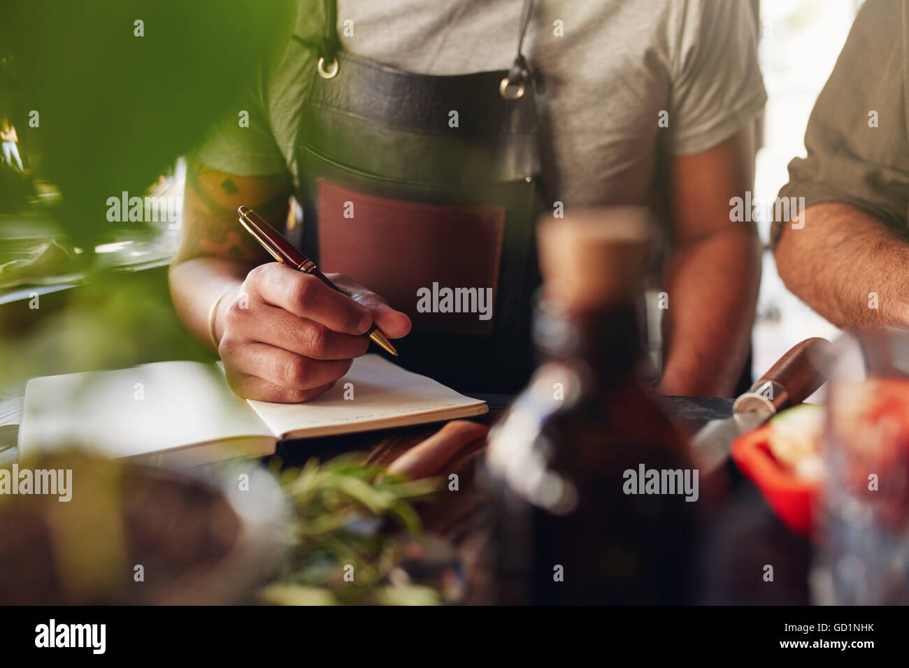 Man writing down notes while creating new cocktail recipe. Bartender ...