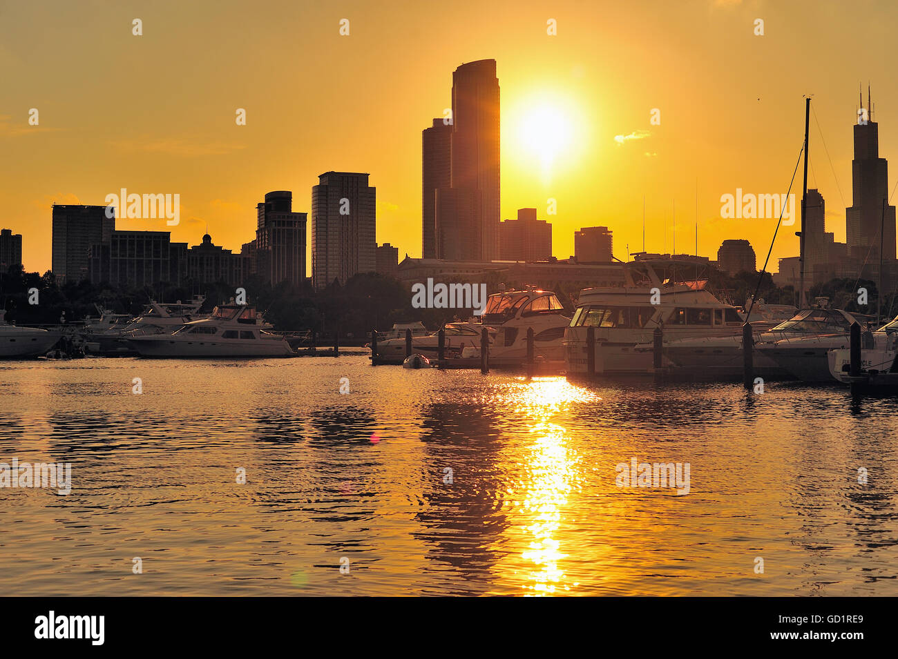 The setting sun creates a golden glow in the sky and into Chicago's ...
