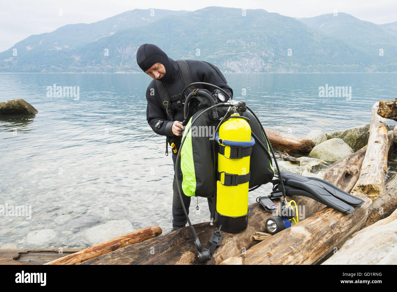 A scuba diver prepares his equipment before making a dive, Britannia ...
