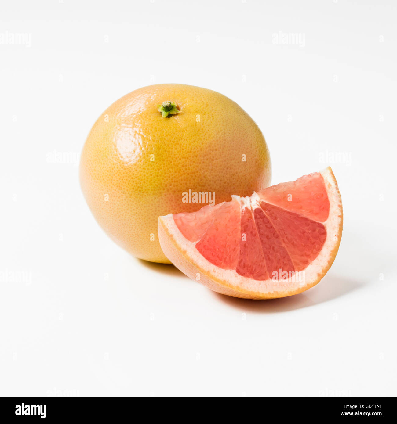 Whole grapefruit and a slice on a white background; Toronto, Ontario ...