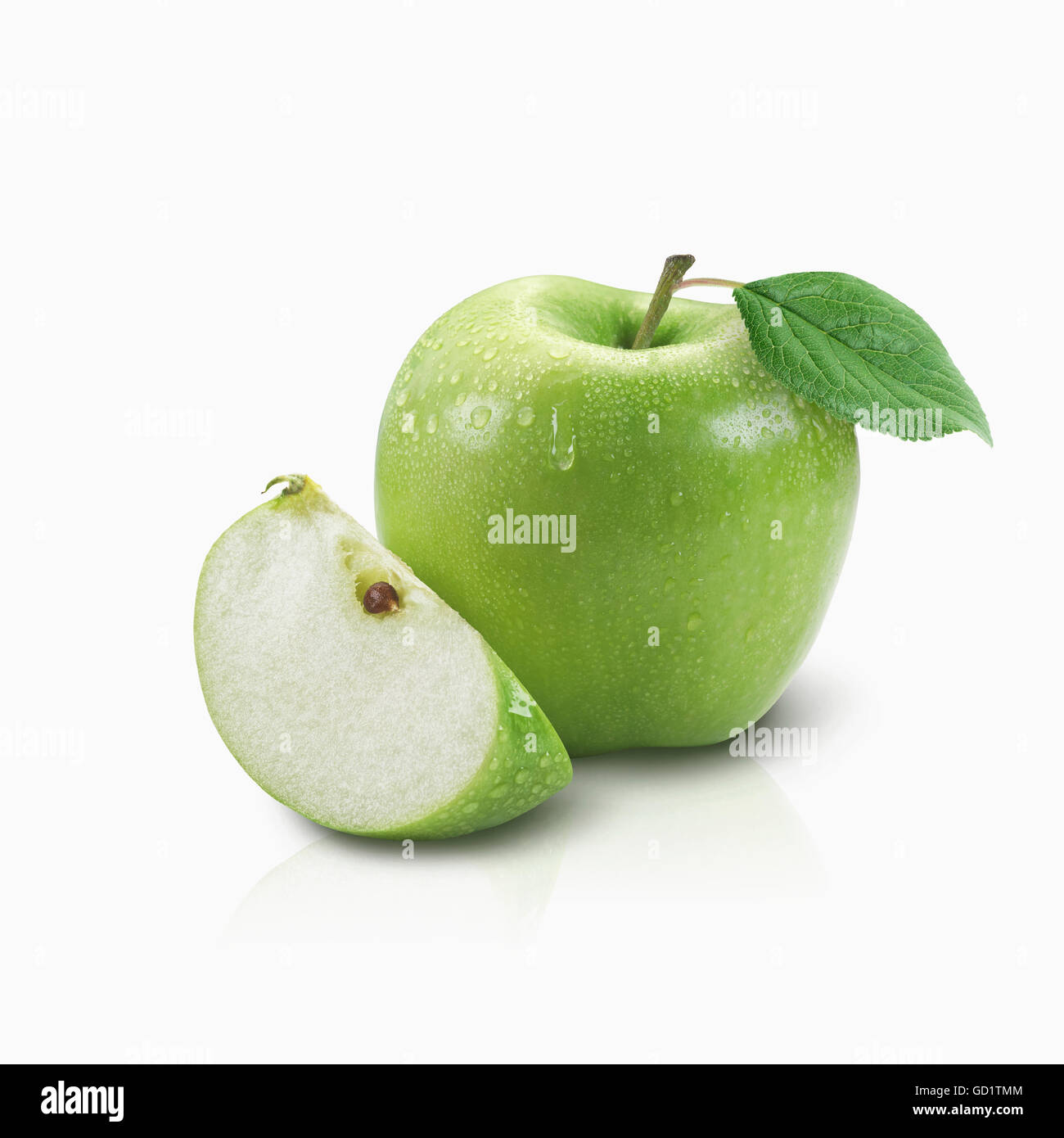 A green apple with a leaf on it's stem, and a wedge of cut apple ...