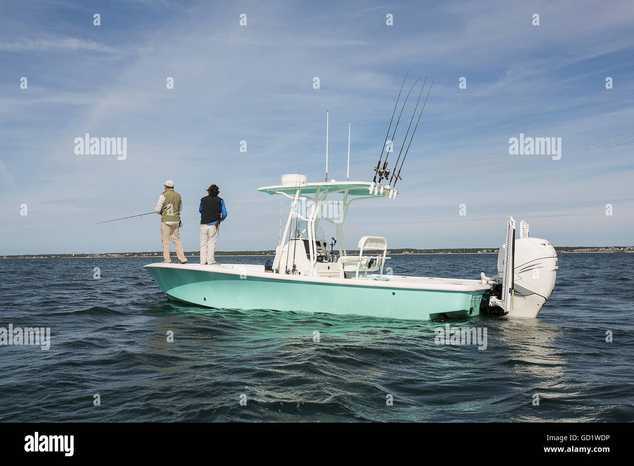 Men standing on the end of a fishing boat and fishing in the Atlantic ...