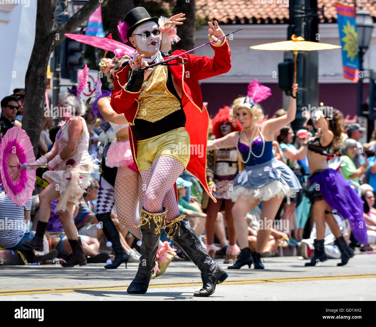 A group of dancers led by a man in shorts and makeup at the yearly ...
