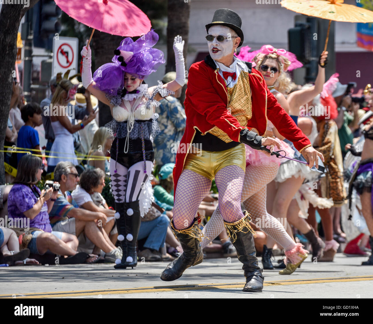 A group of dancers led by a man in shorts and makeup at the yearly ...